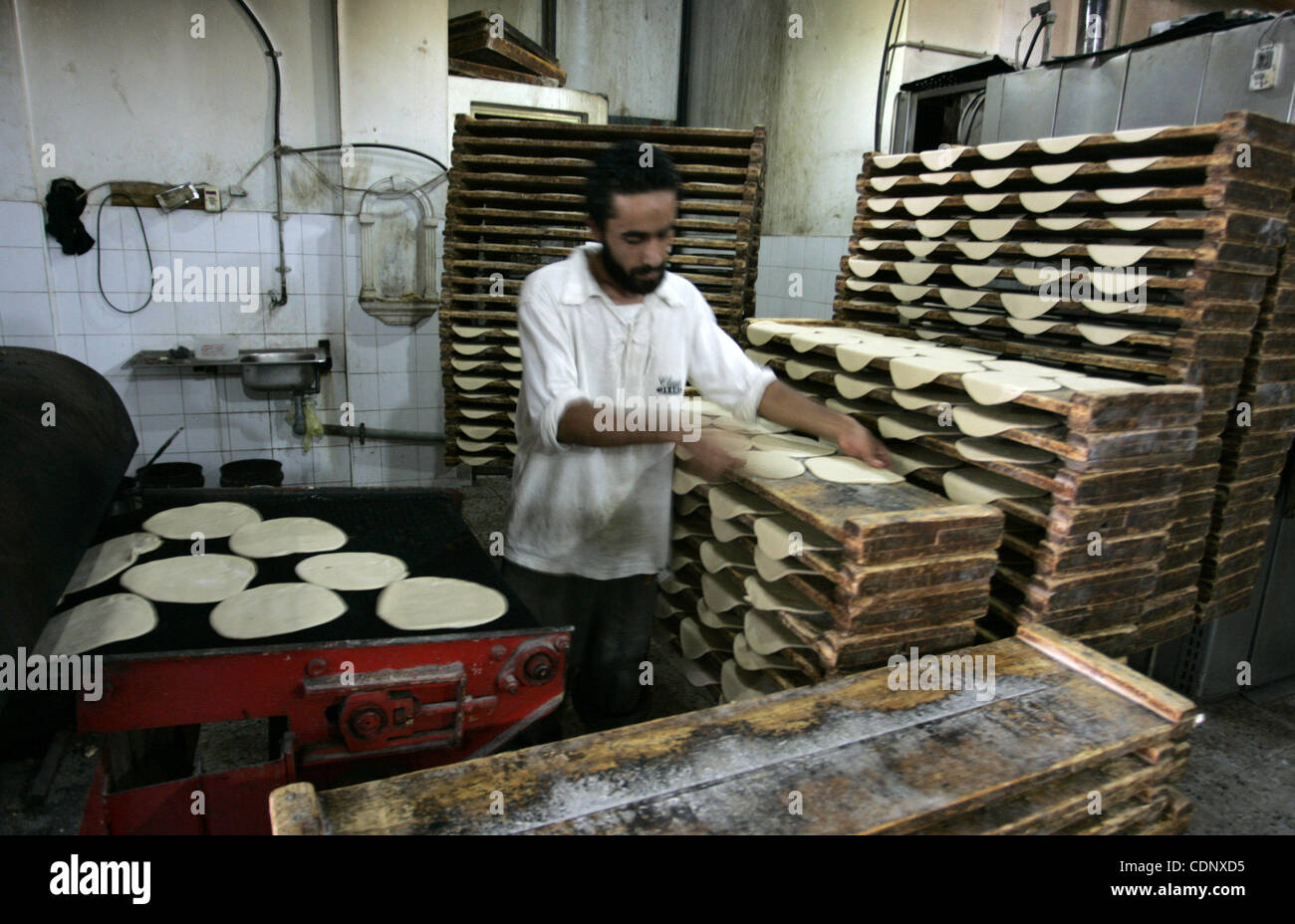 A Palestinian baker prepares bread at his bakery in Rafah, southern ...