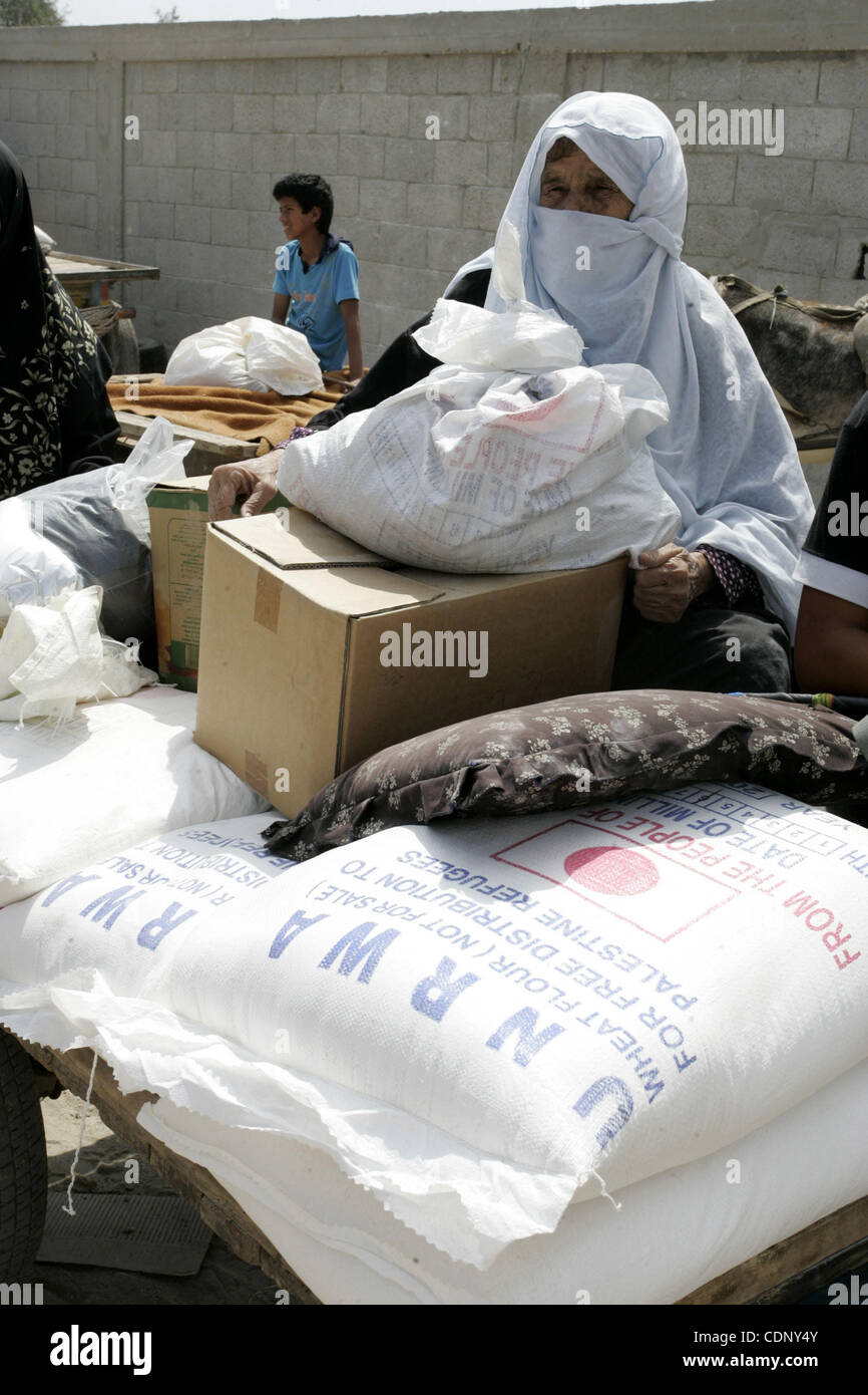 A Palestinian woman receives humanitarian aid at the United Nations aid ...