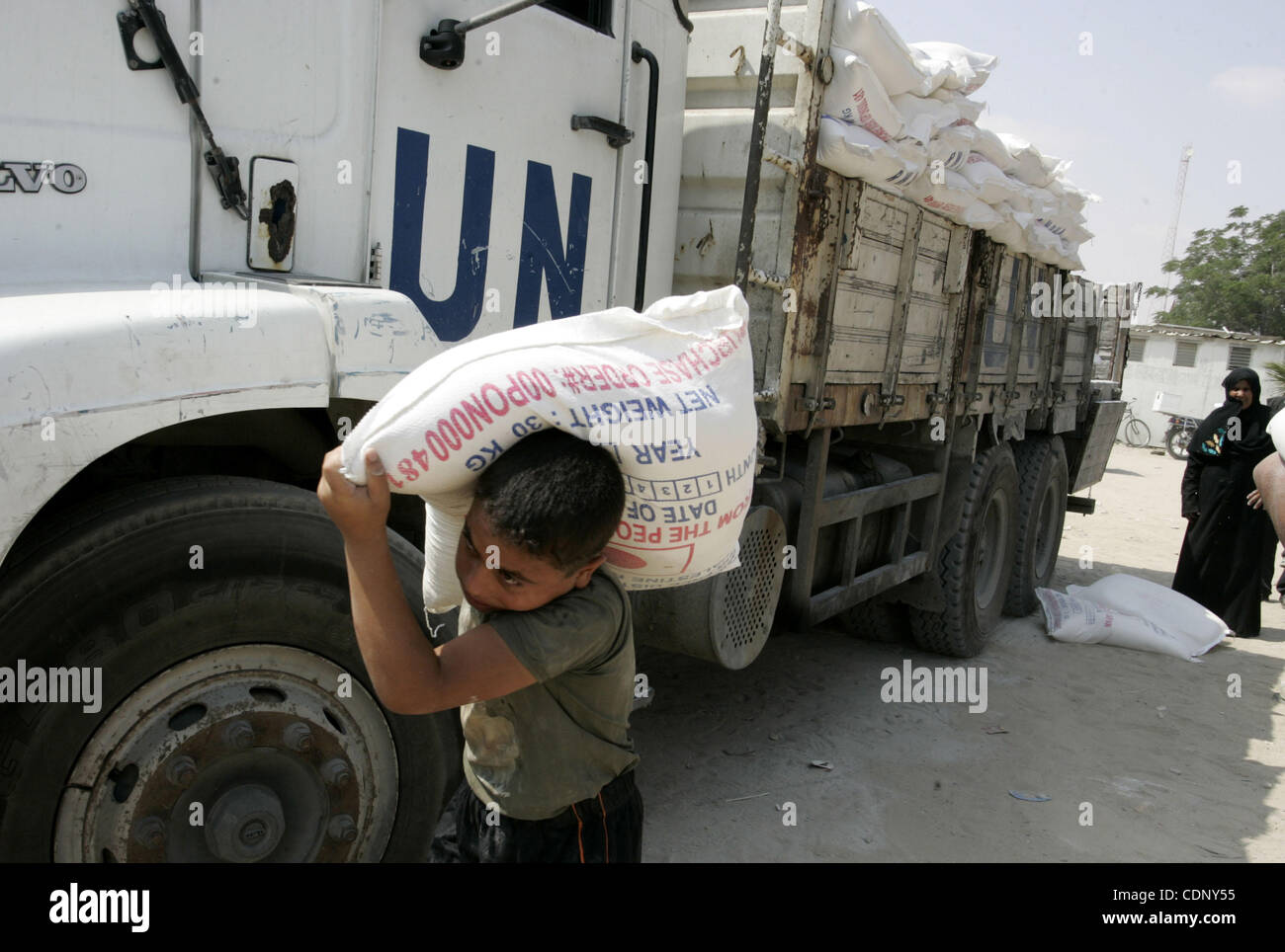 Palestinians receive humanitarian aid at the United Nations aid ...