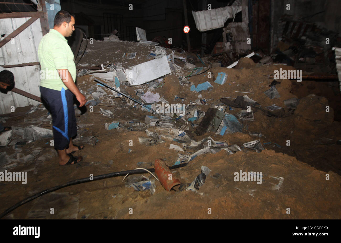 A Palestinian man inspects debris in a destroyed car wash garage after ...