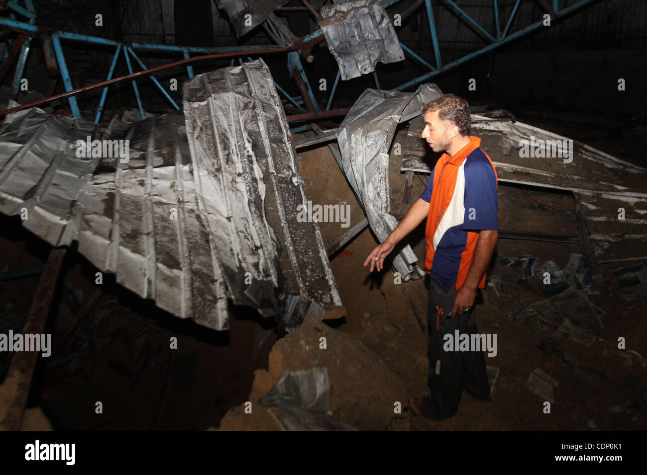 A Palestinian man inspects debris in a destroyed car wash garage after ...
