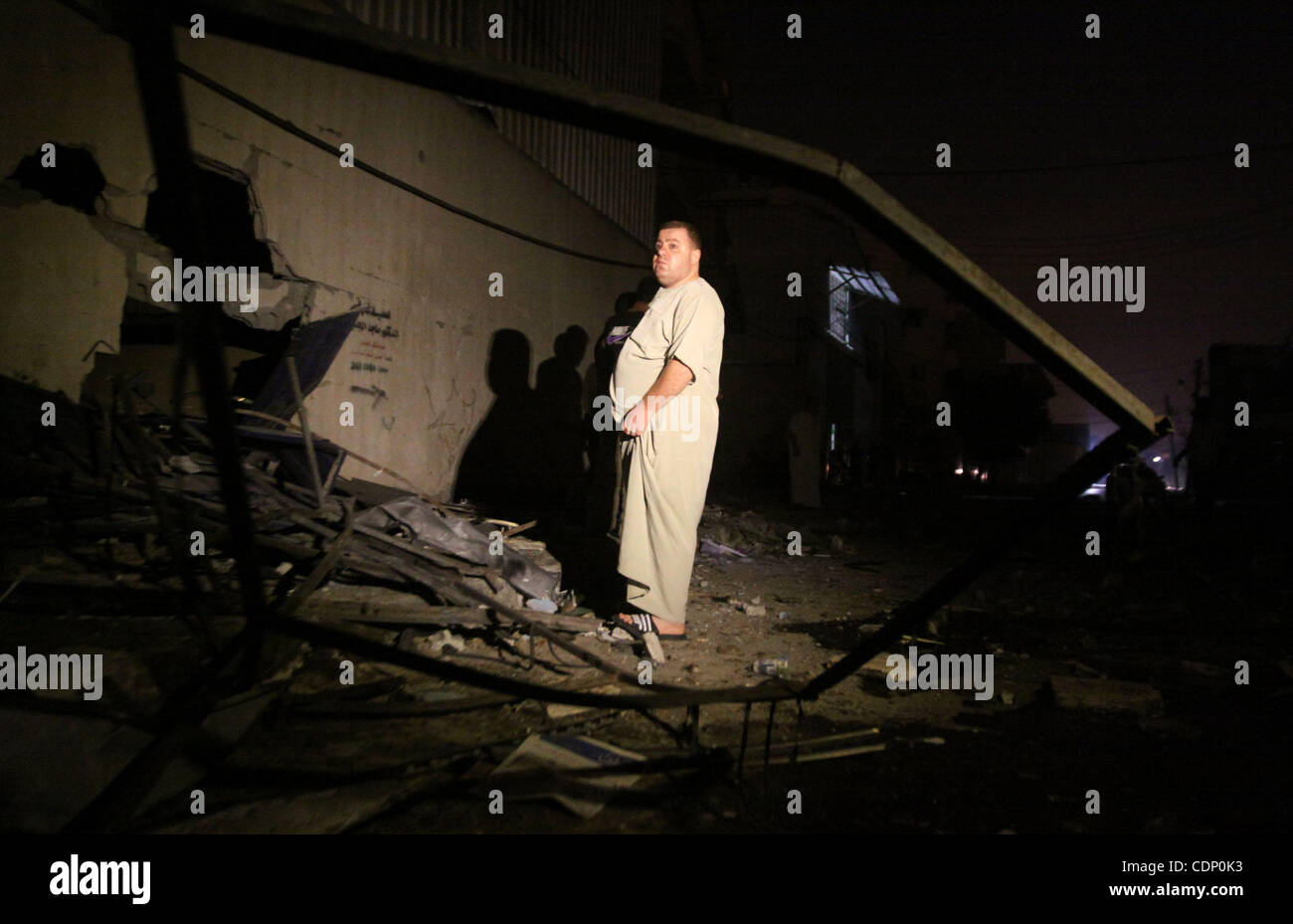 A Palestinian man inspects debris in a destroyed car wash garage after ...