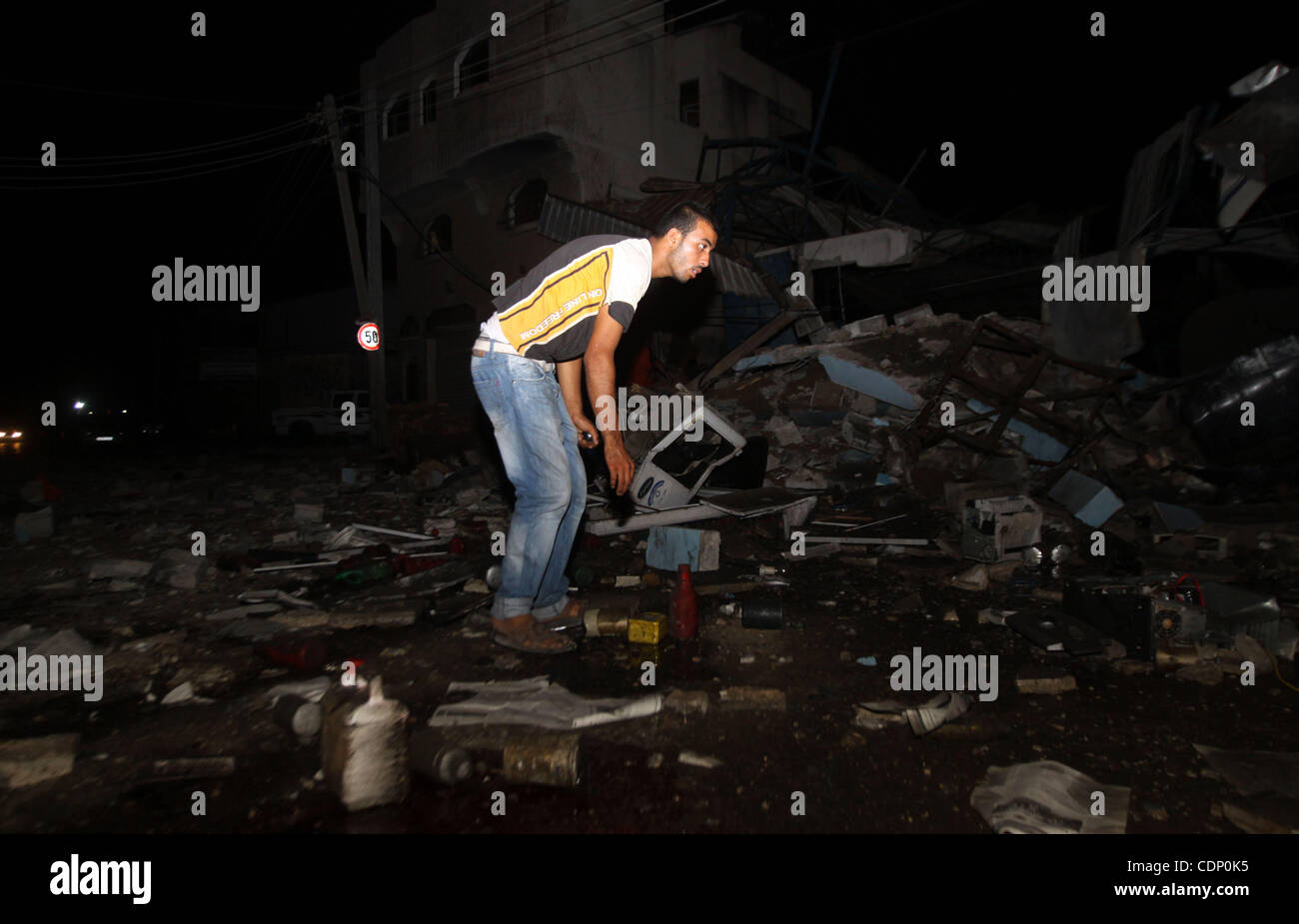 A Palestinian man inspects debris in a destroyed car wash garage after ...