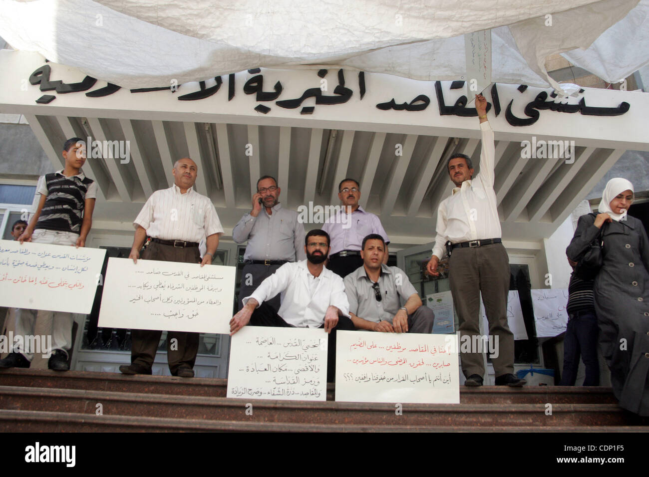 Palestinian staff hold banners in a protest in Al Makassed hospital in ...