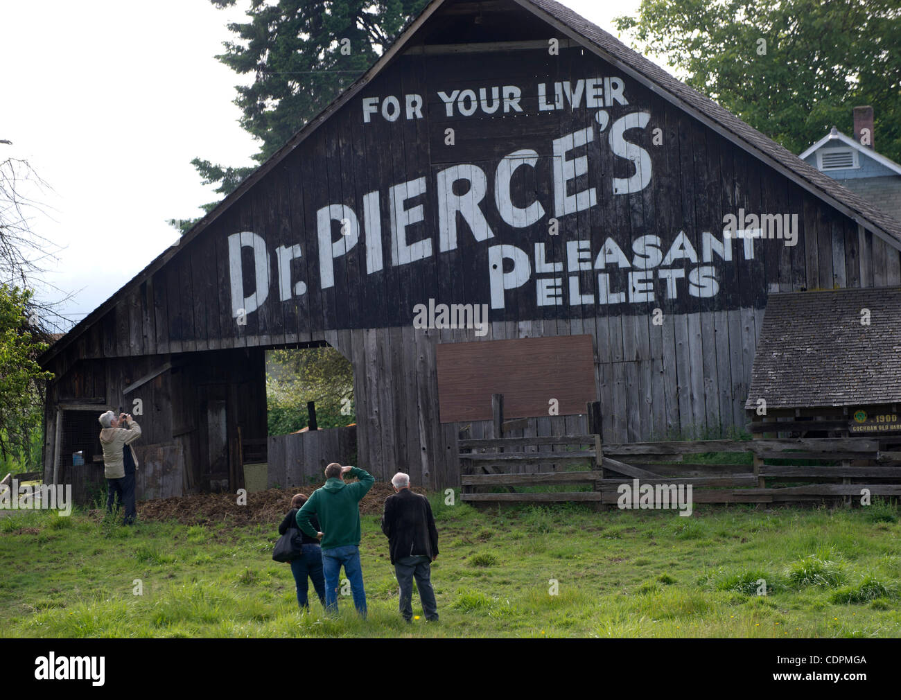 June 21, 2011 - Cottage Grove, Oregon, U.S - Tourists inspect a barn with an old advertisement ...