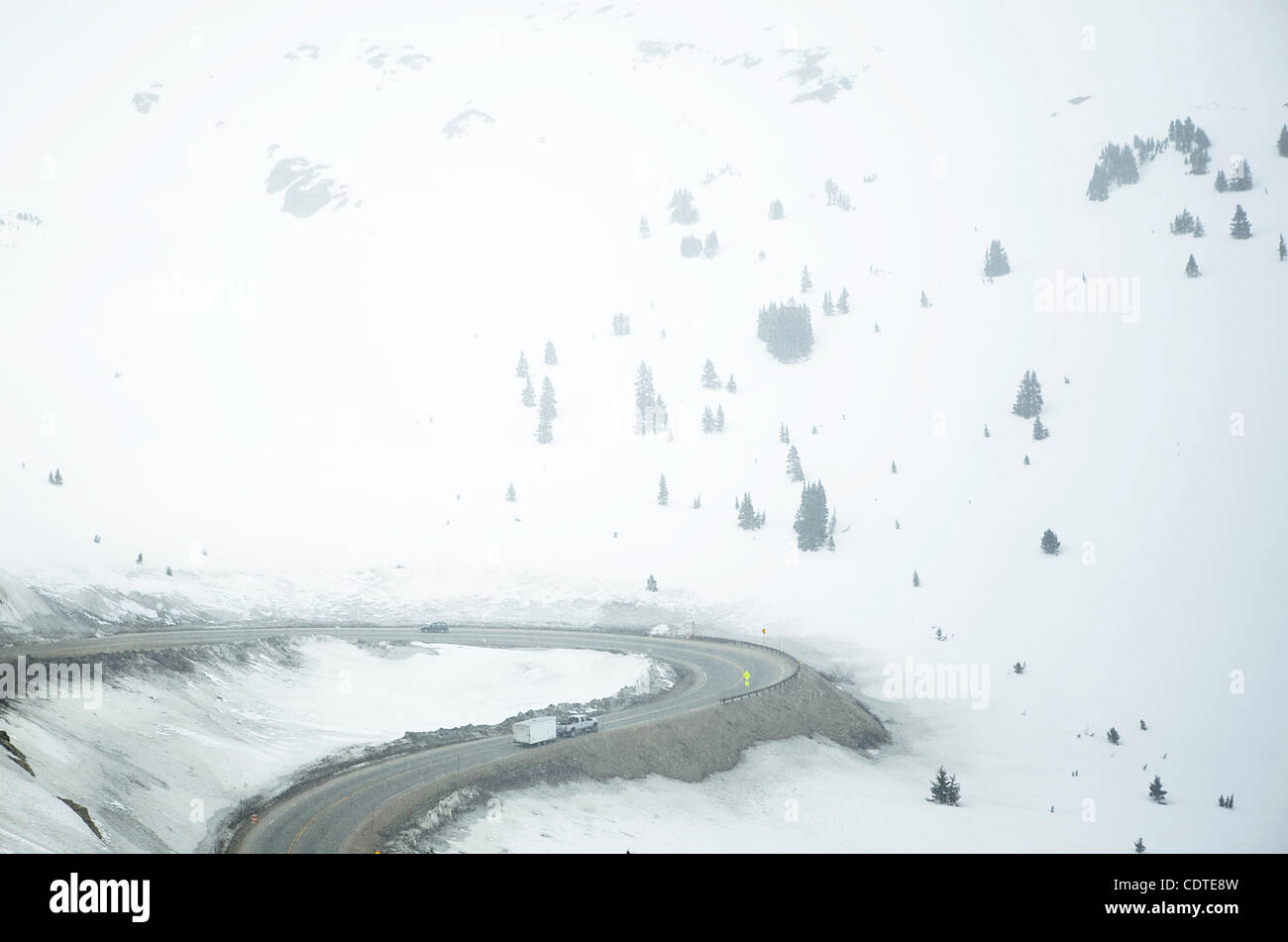 Cars make their way up Loveland Pass through snowfall and snow drifts ...
