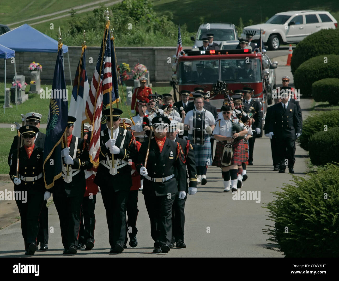 A color guard along with drummers and bagpipers lead the fire engine ...