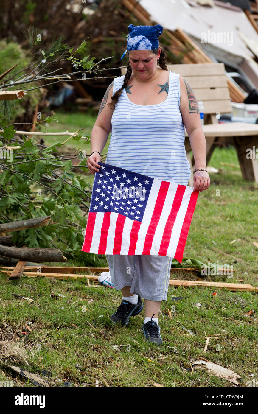 A resident of Joplin, Missouri carries an American flag after a Tornado ...