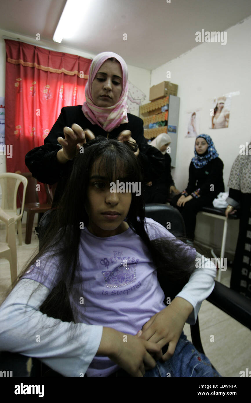 A Palestinian woman applies makeup on the face of a girl during a ...