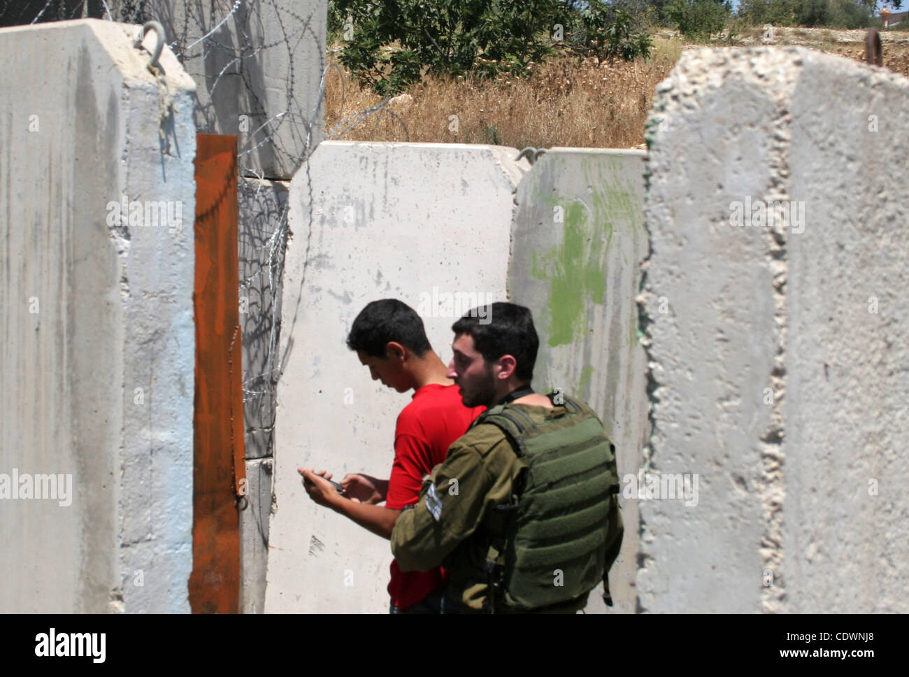An Israeli soldier detains a protester during a demonstration by ...
