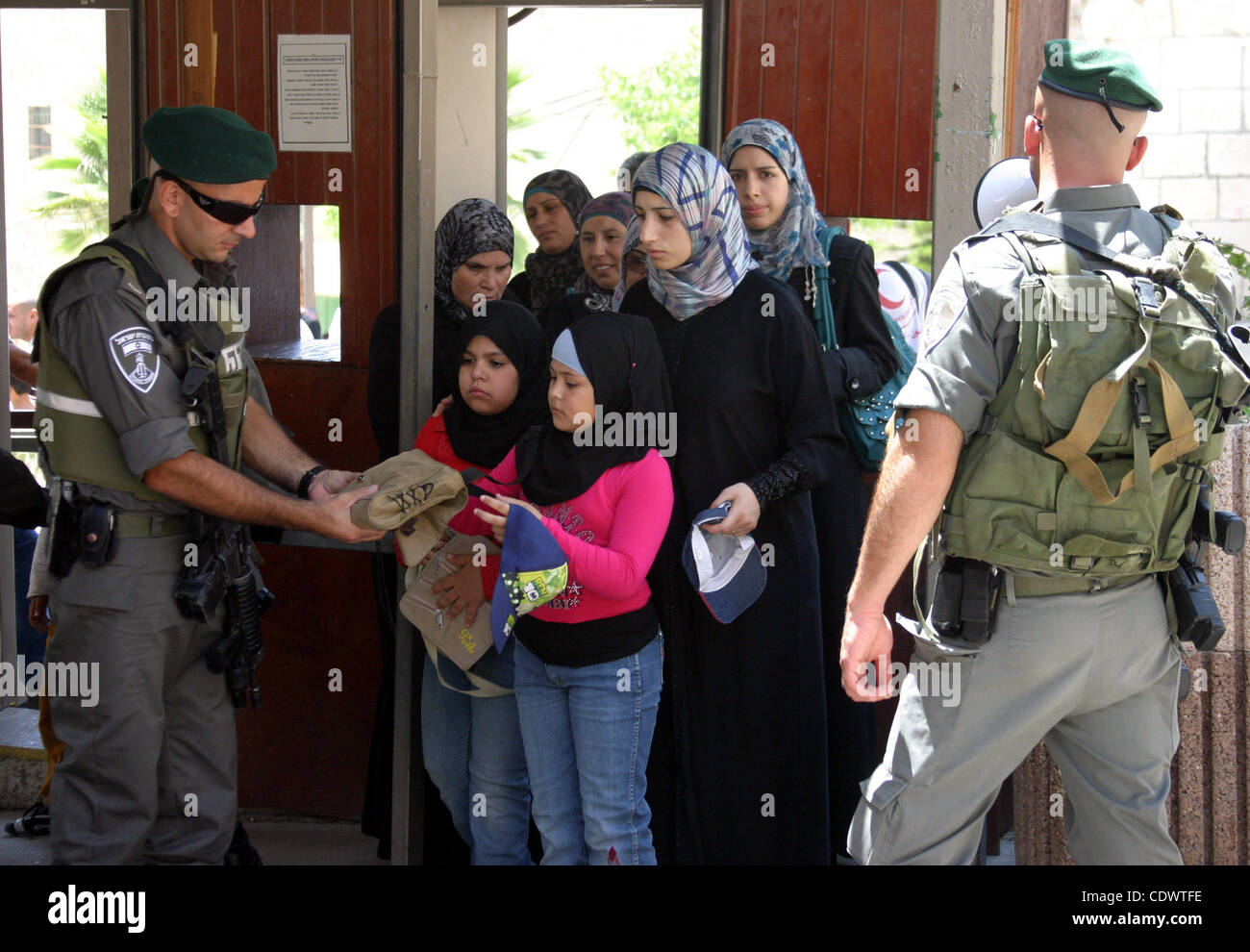 Palestinian women are being checked at an Israeli army checkpoint on ...