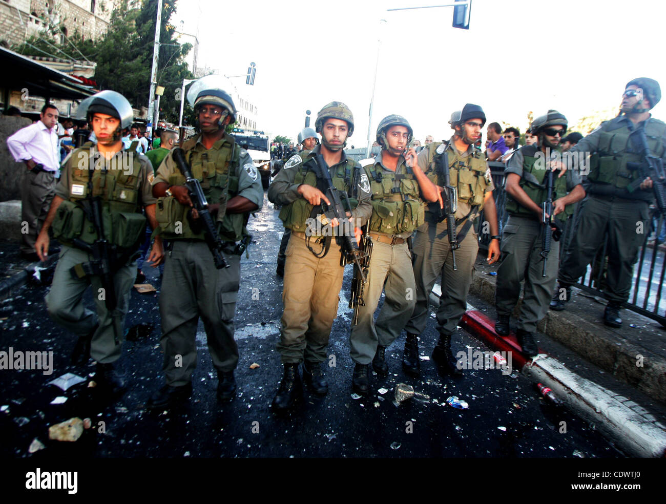 Israeli border guard keep watch Palestinians as they shop at a market ...