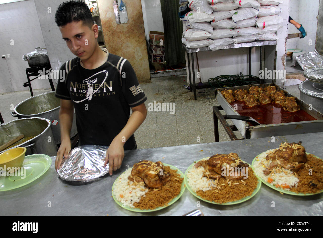 Palestinian bakers prepare chicken and rice 'Qedrah" in a traditional ...
