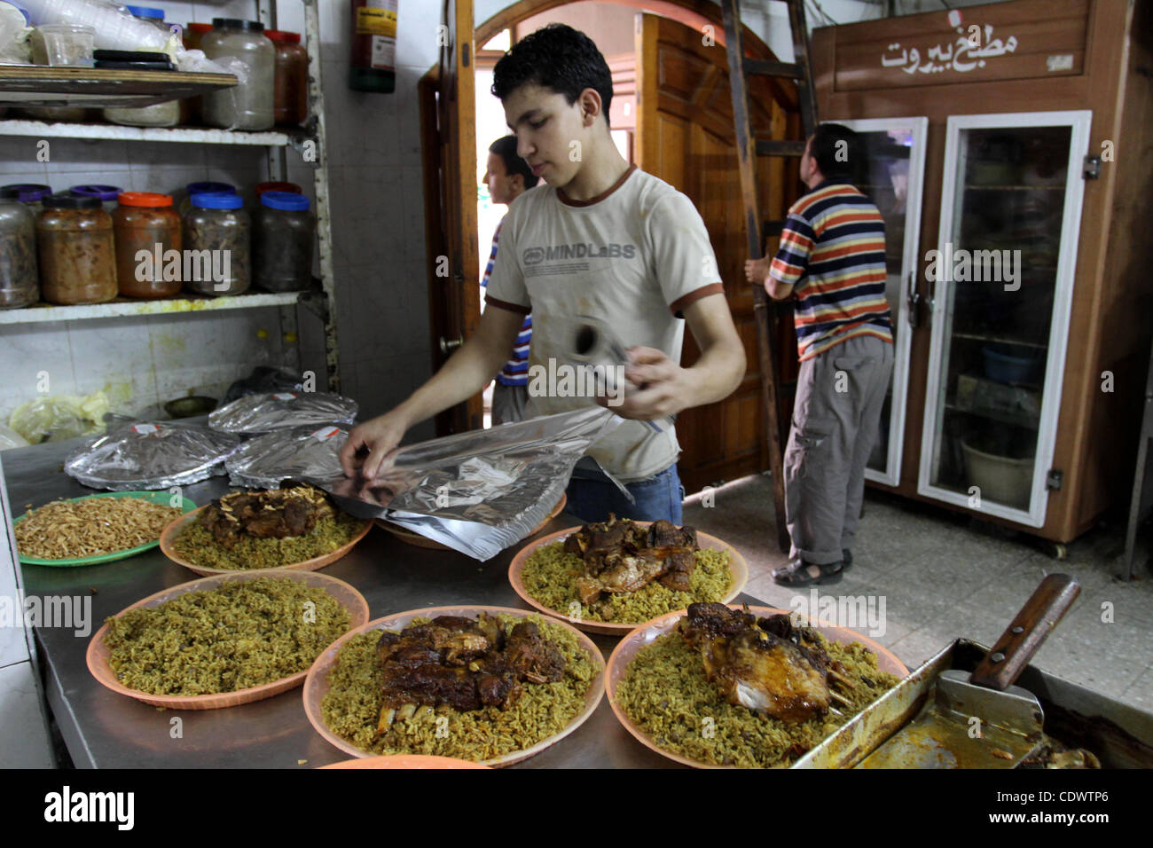 Palestinian bakers prepare chicken and rice 'Qedrah" in a traditional ...