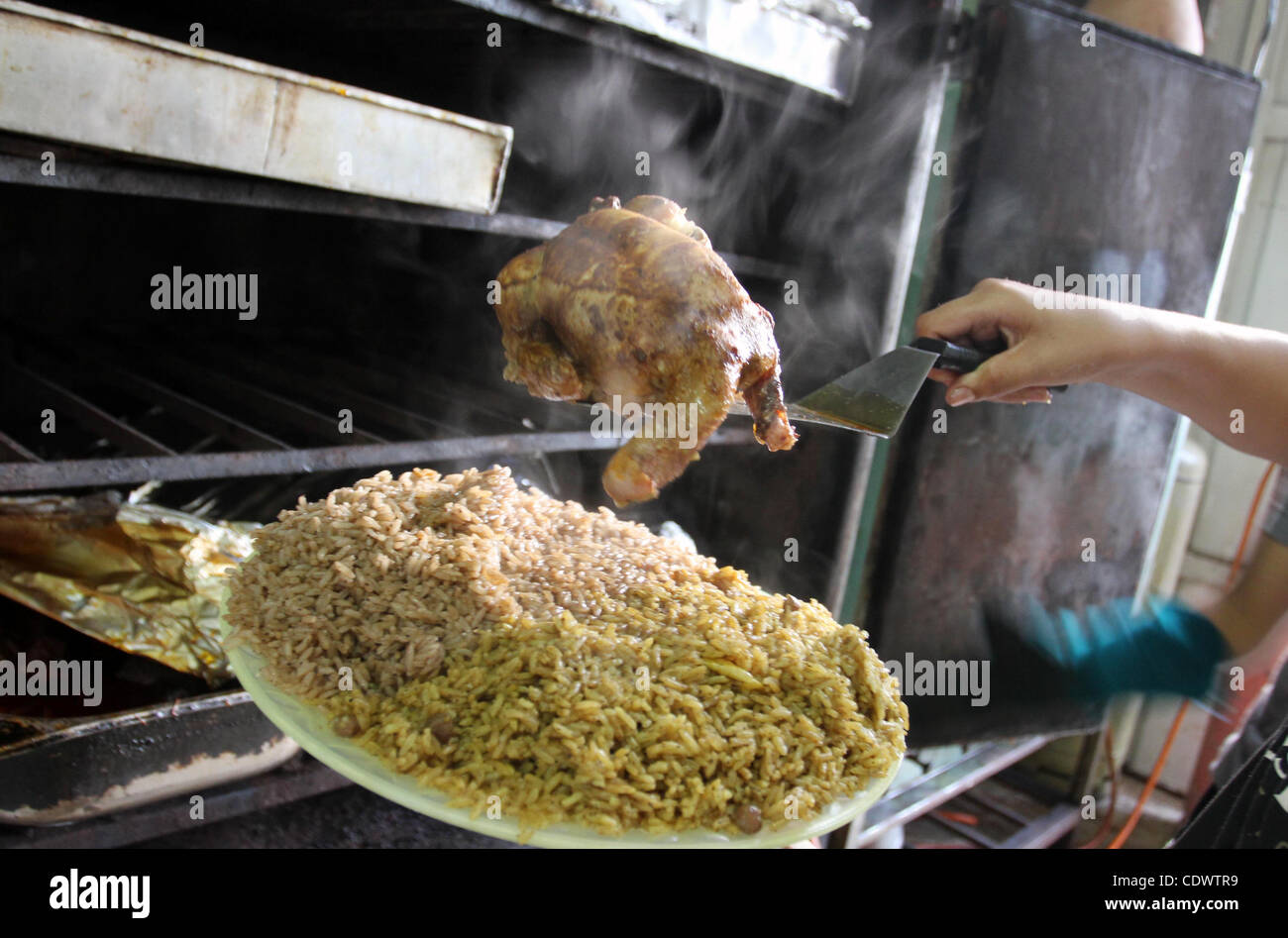 Palestinian bakers prepare chicken and rice 'Qedrah" in a traditional ...