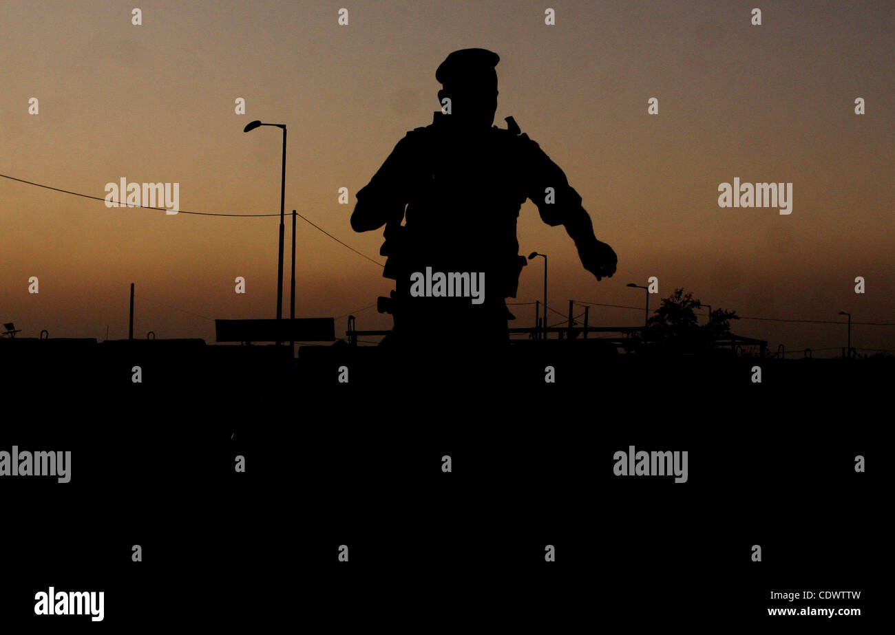 An Israeli soldier stands guard at Israel's Qalandiya checkpoint as ...