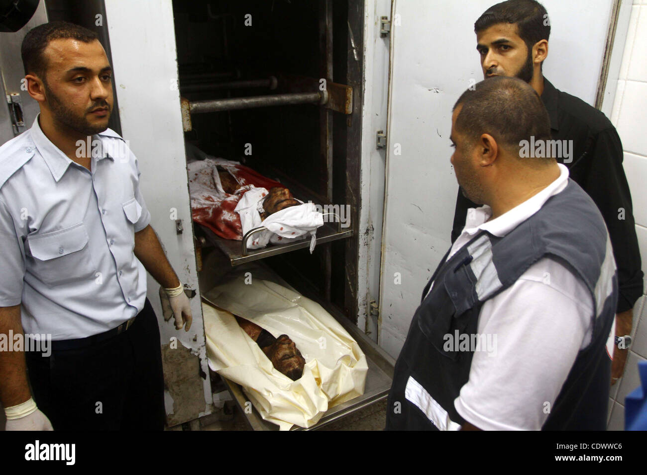 Palestinian men gather around the bodies of Emad Abu Abda and Anwar ...