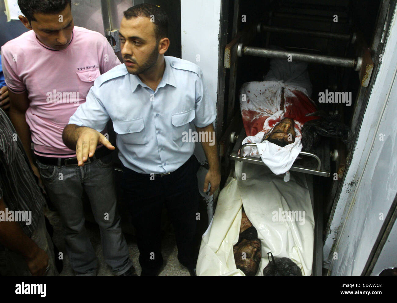 Palestinian men gather around the bodies of Emad Abu Abda and Anwar ...
