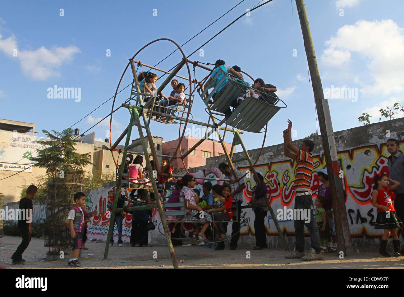 Palestinian children enjoy a ride at an amusement park on the second ...