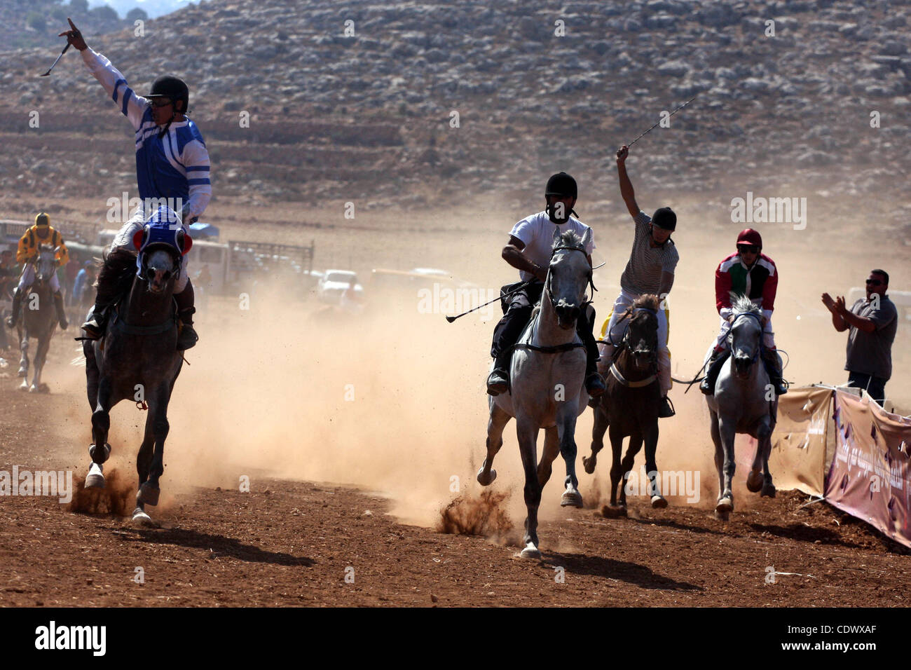 Palestinian jockeys compete during a horse race in the West Bank ...