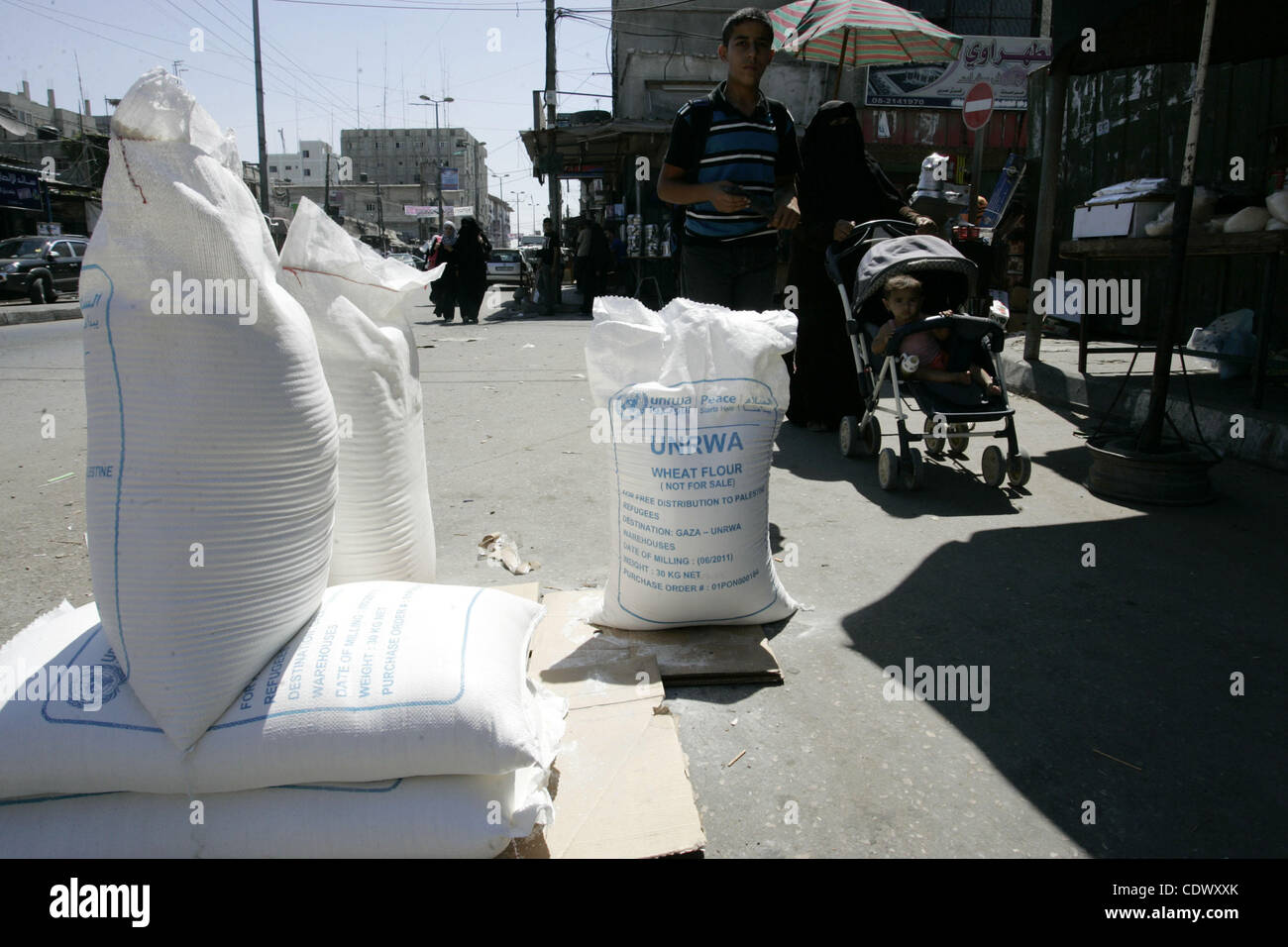 Palestinians receive their food aid from a UN distribution centre in ...