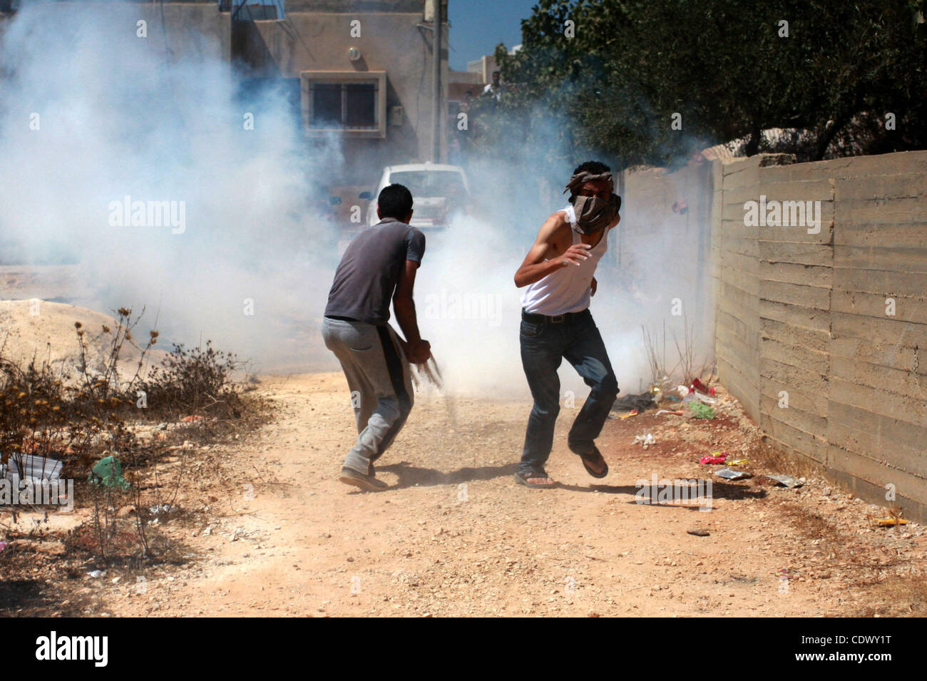 Palestinians take cover from tear gas during clashes at Qusra village ...