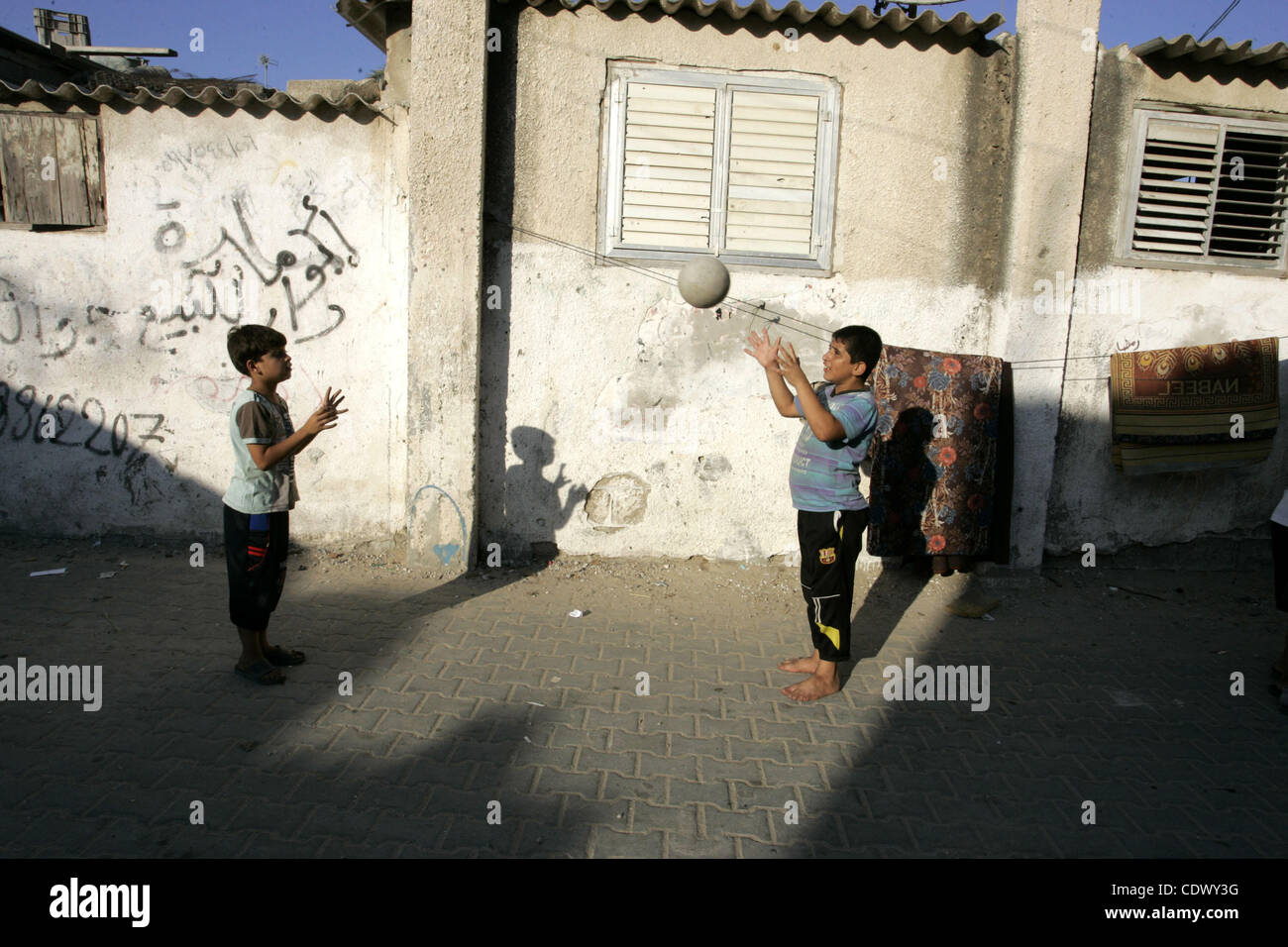 Palestinian children play football outside their house at Rafah refugee ...