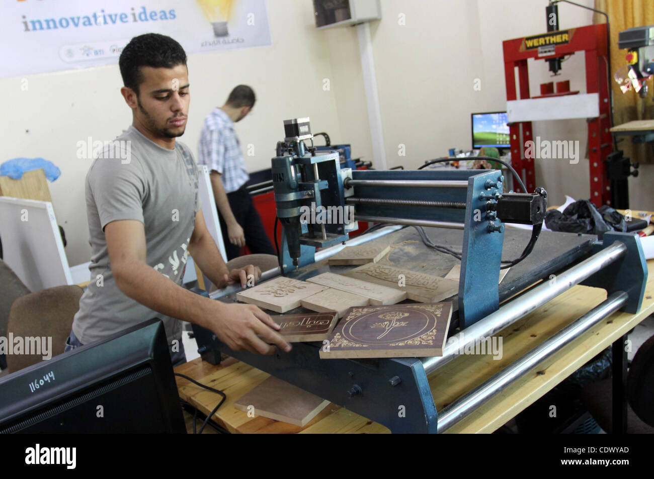 A Palestinian engineering collage student works on hand-made machine at ...