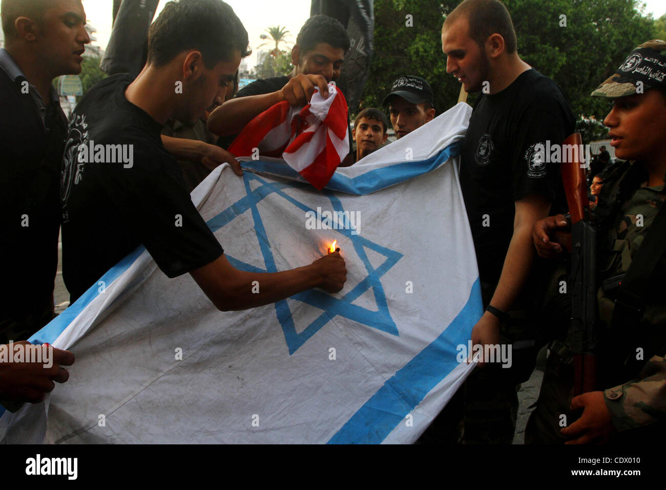 Palestinian militants of Popular Resistance Committees burn an Israeli ...