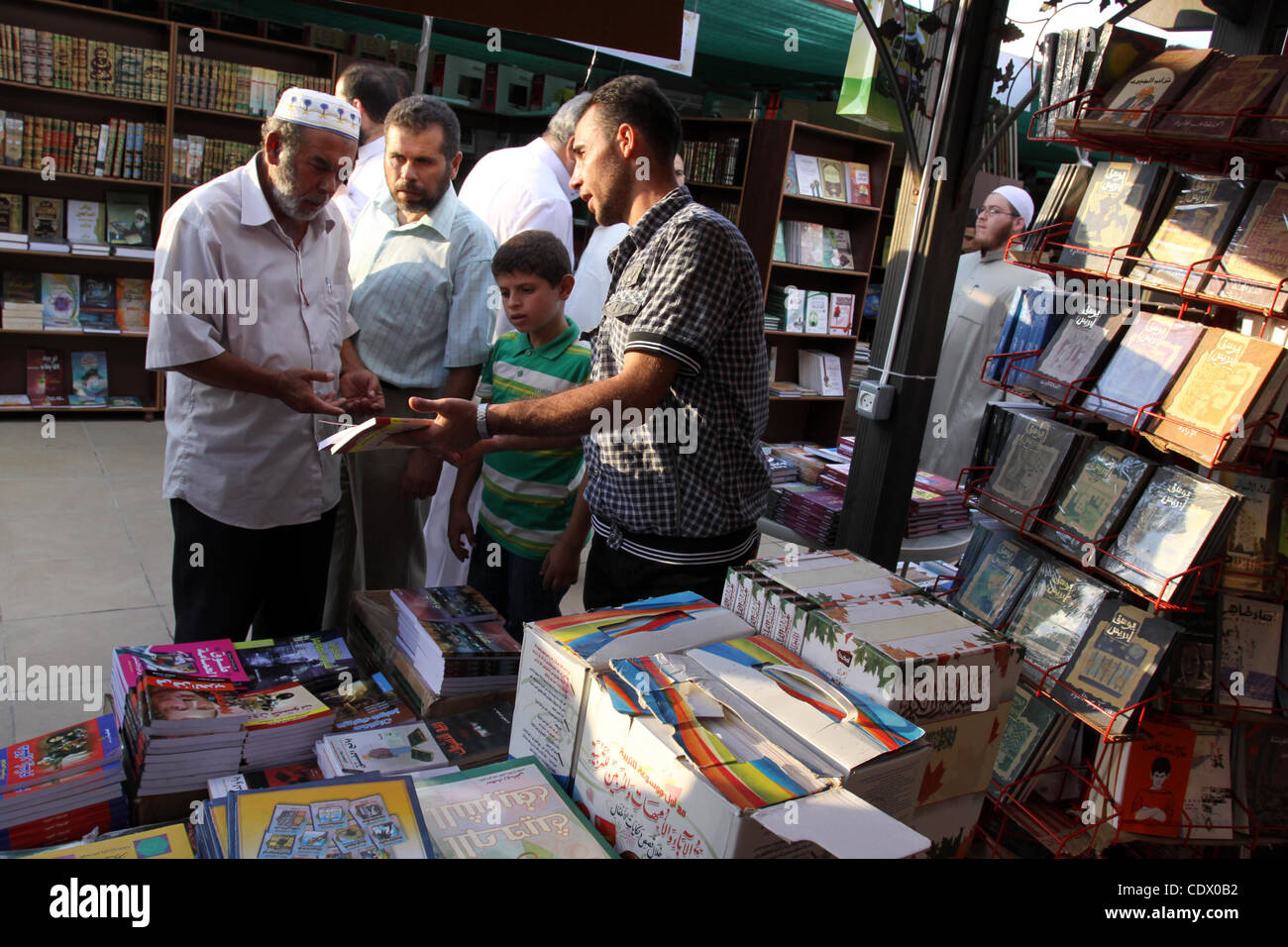 Palestinians search for books during the opening ceremony of the book ...