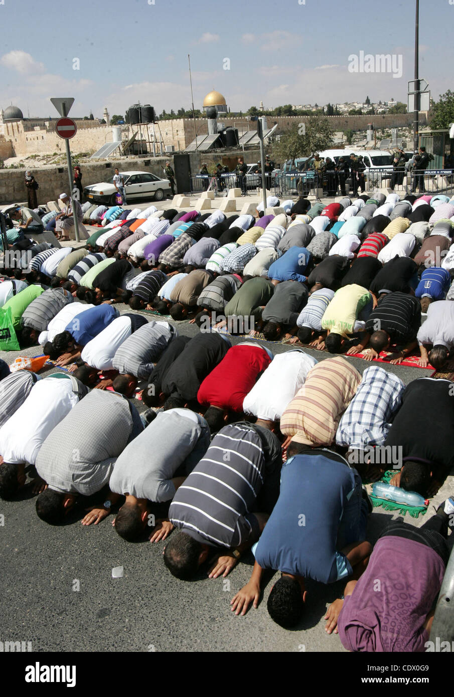 Palestinian Muslims attend Friday prayers at a street in the ...