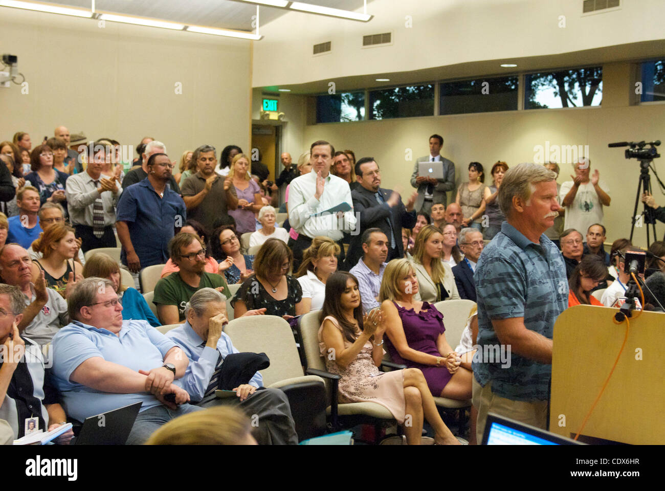Kelly's father, Ron Thomas, at the podium. Crowds gather in protest of ...