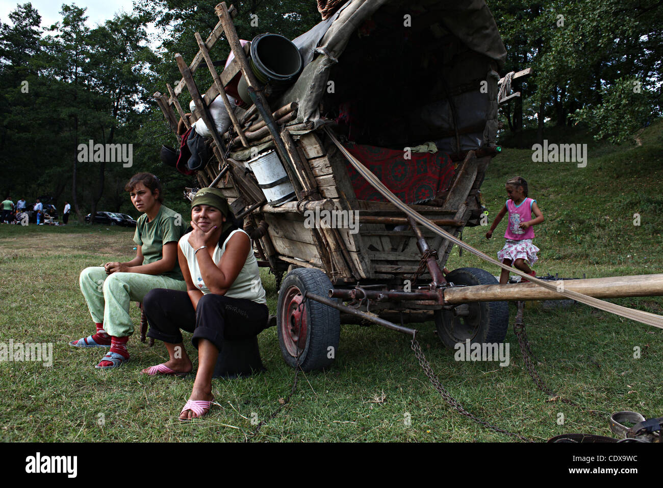 Two gypsy women rest in front of the cart where they live as nomads ...