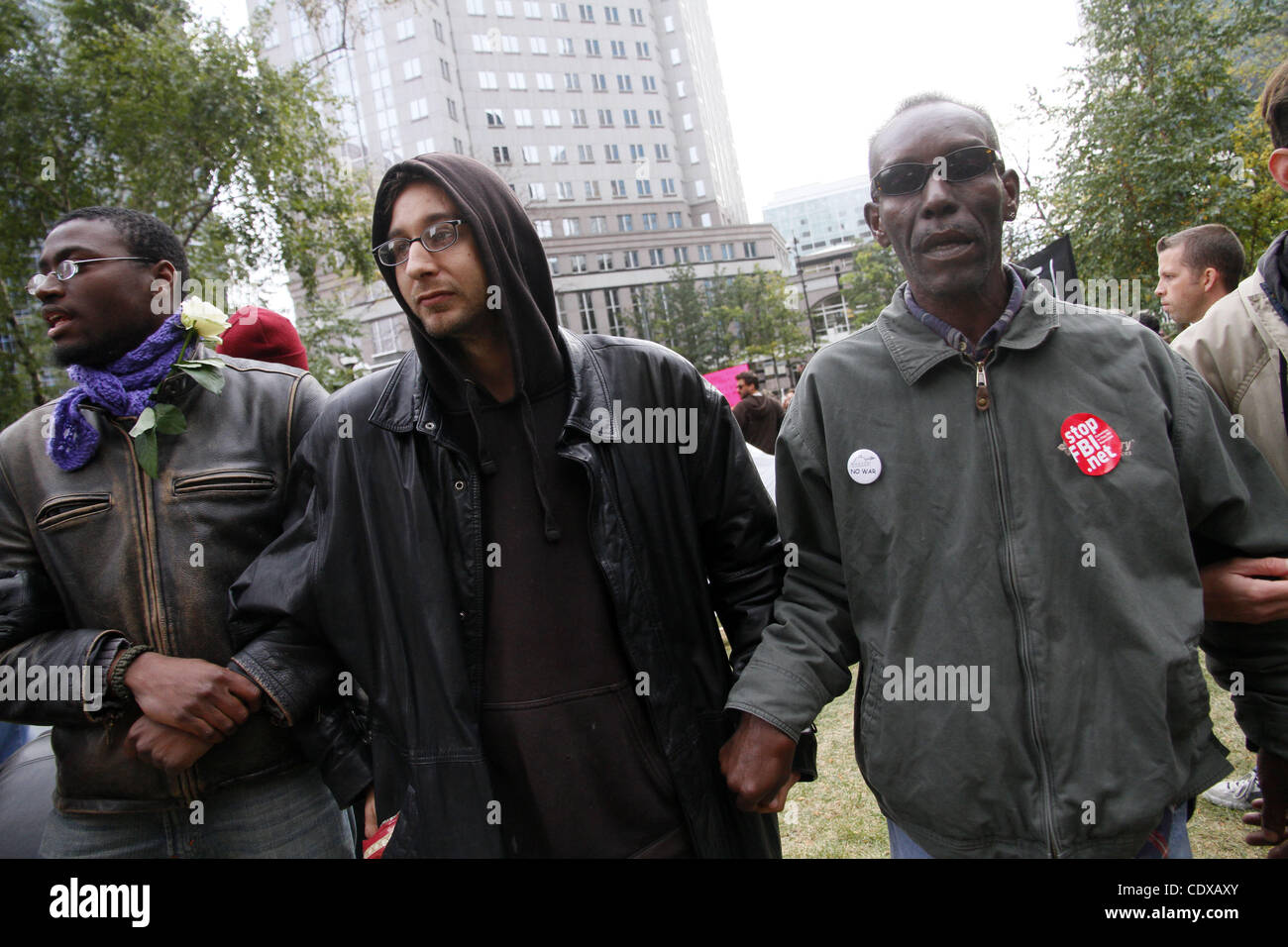 Civil disobedience protesters lock arms around a set of clear tents ...