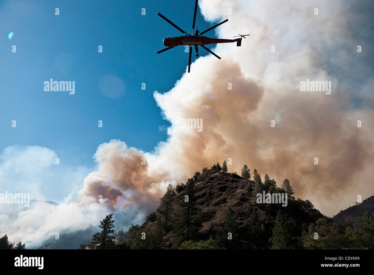 A Sikorski firefighting helicopter heads toward the fire's front at the ...