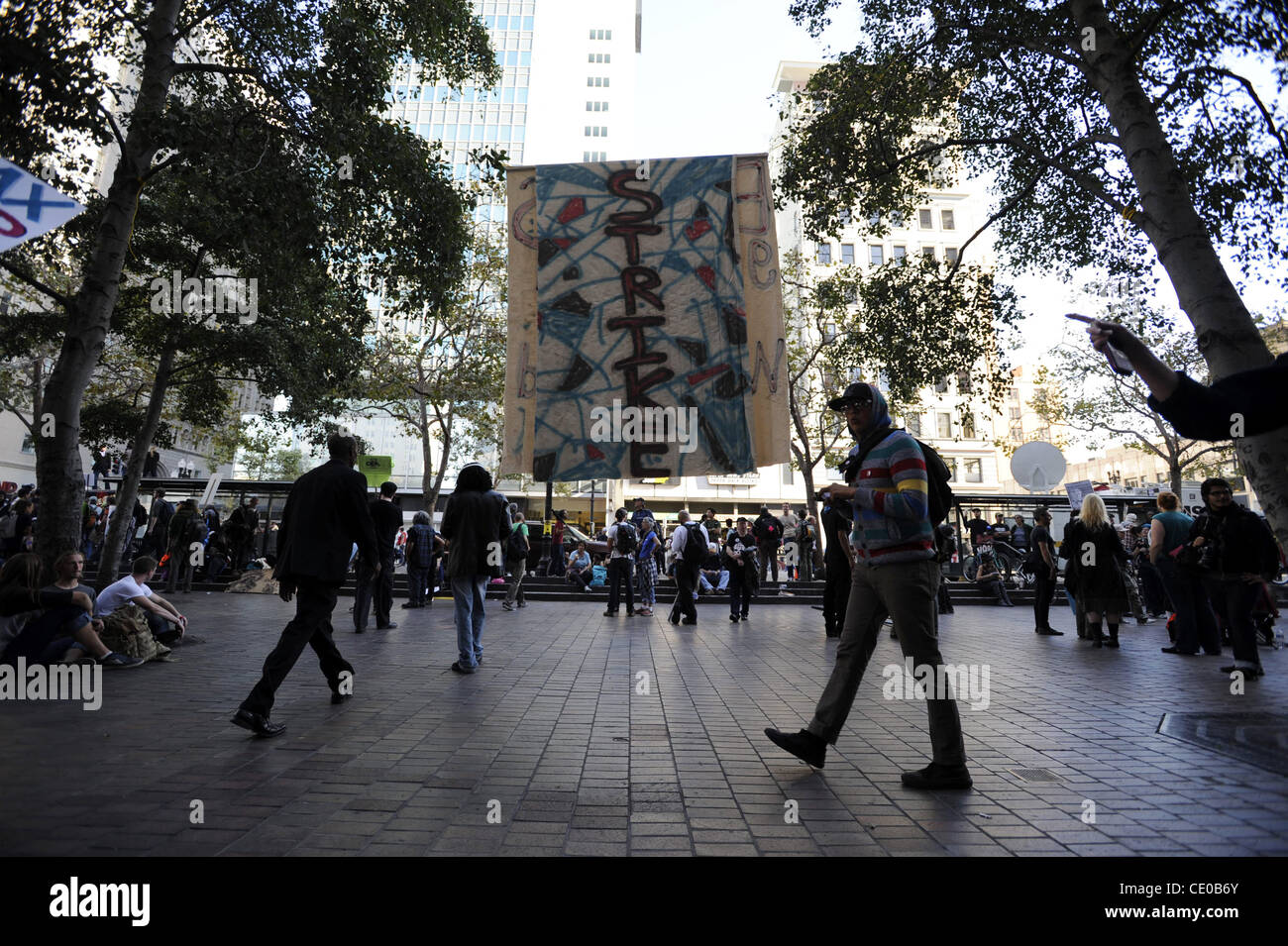 A large banner hangs between two trees in a corporate plaza in downtown ...