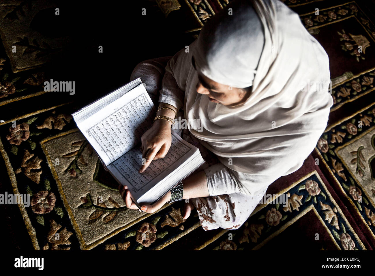 Muslim woman reading the Koran at the Jamia Masjid or grand mosque at ...