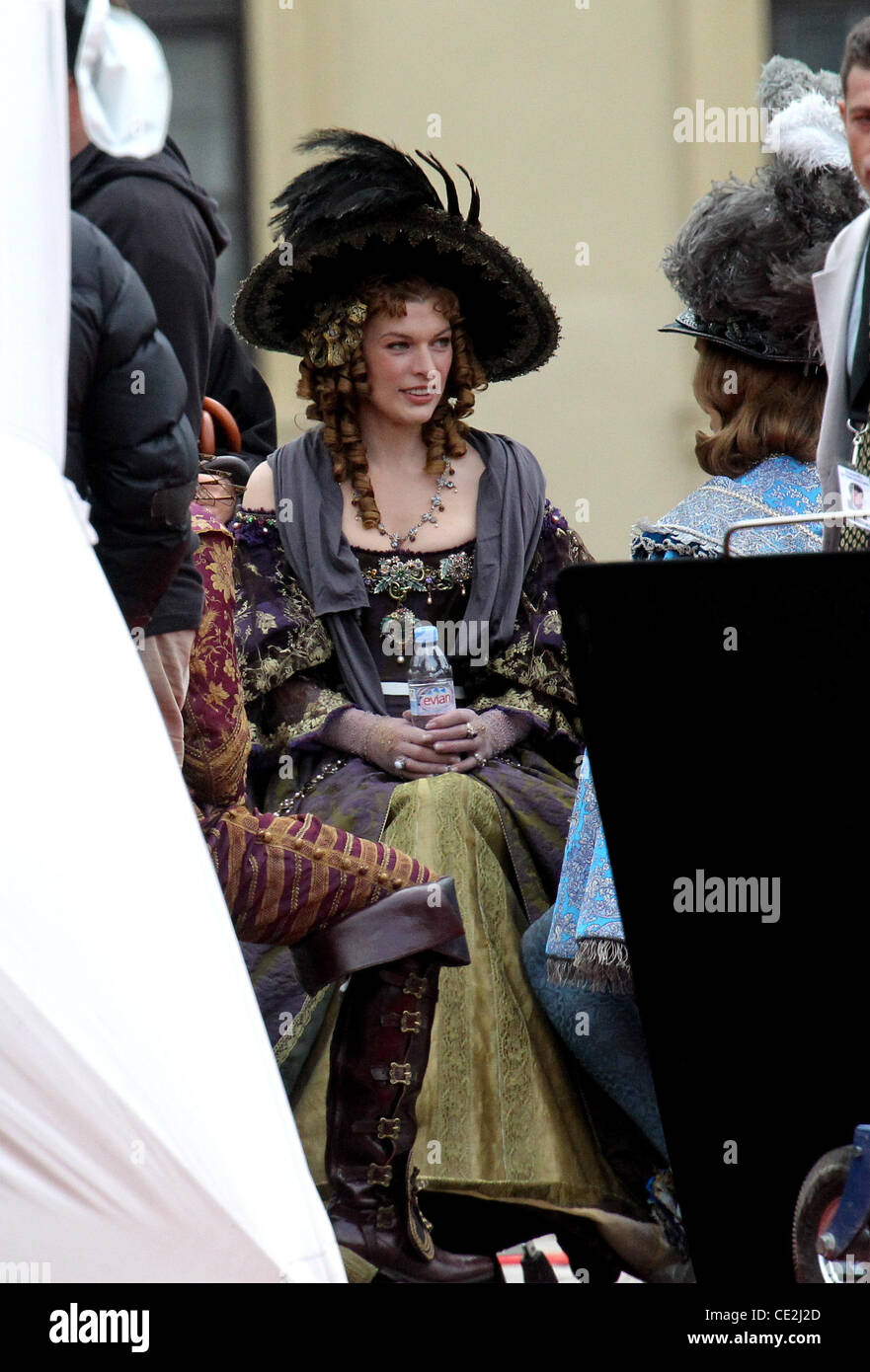 Milla Jovovich with a bottle of Evian water on the set of 'The Three ...