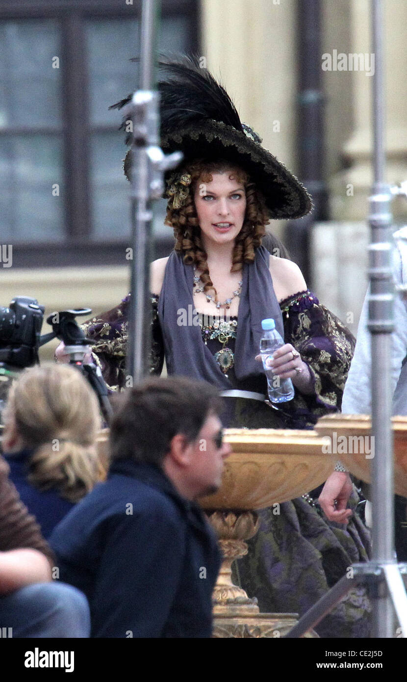 Milla Jovovich with a bottle of Evian water on the set of 'The Three ...