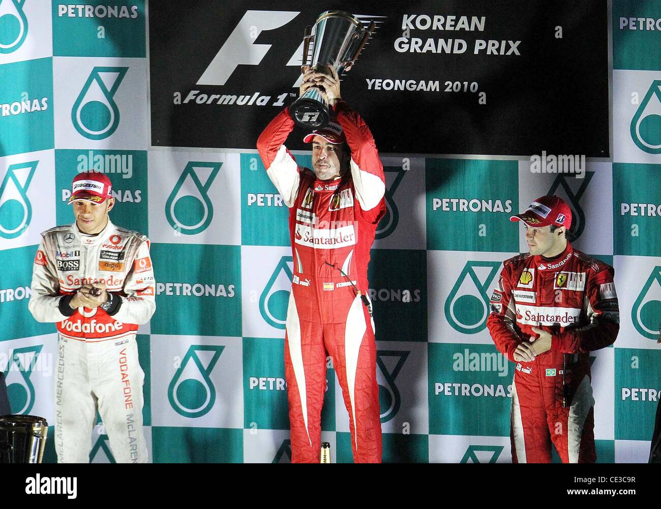 Ferrari Formula One driver Fernando Alonso jumps on the podium as he ...