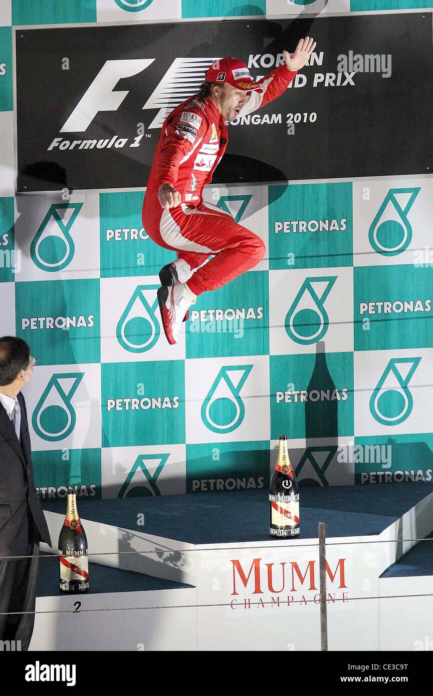 Ferrari Formula One driver Fernando Alonso jumps on the podium as he ...