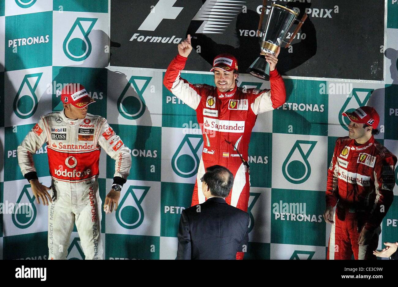 Ferrari Formula One driver Fernando Alonso jumps on the podium as he ...