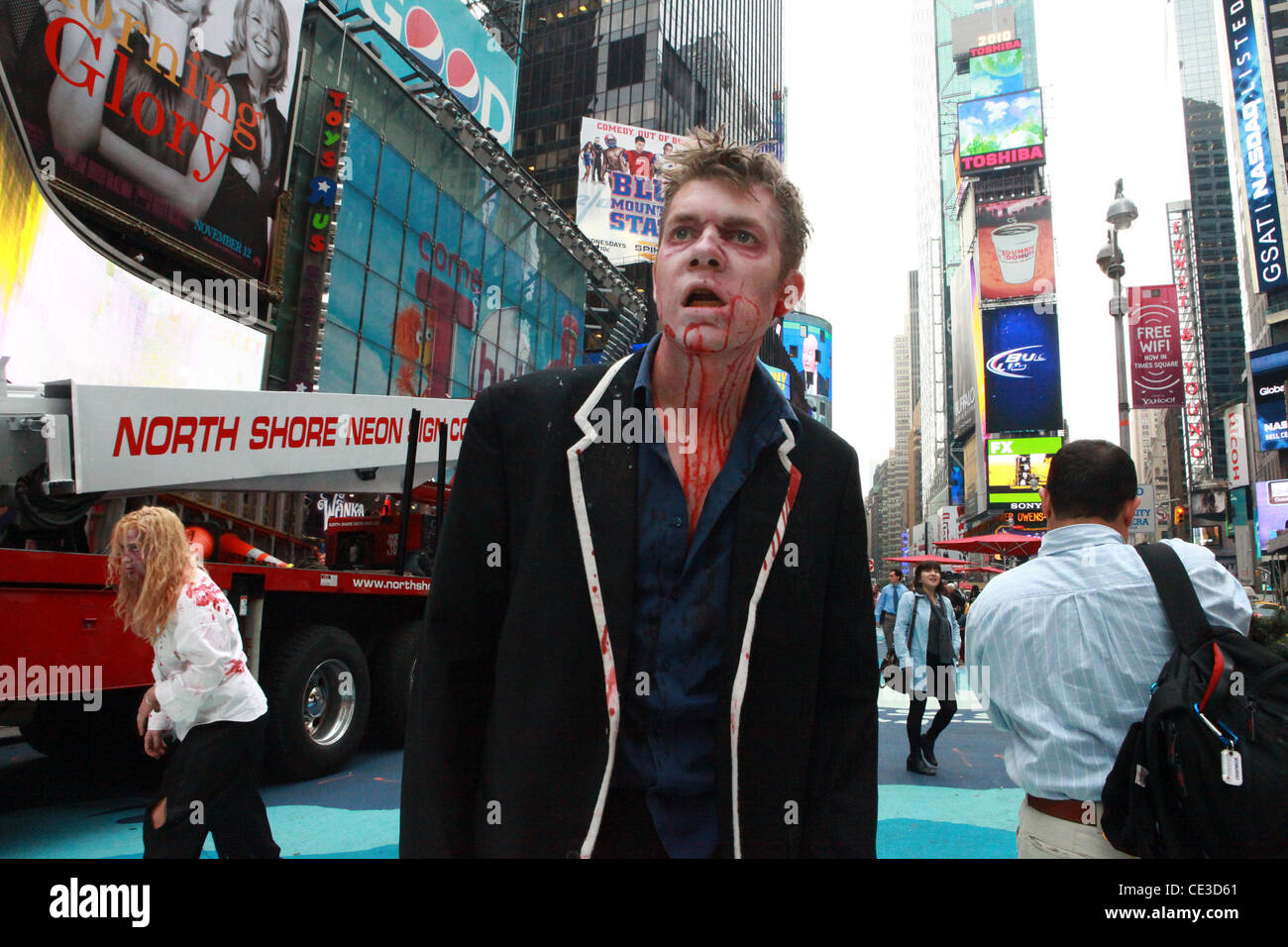 Zombies swarm tourists at Times Square in anticipation of the premiere ...