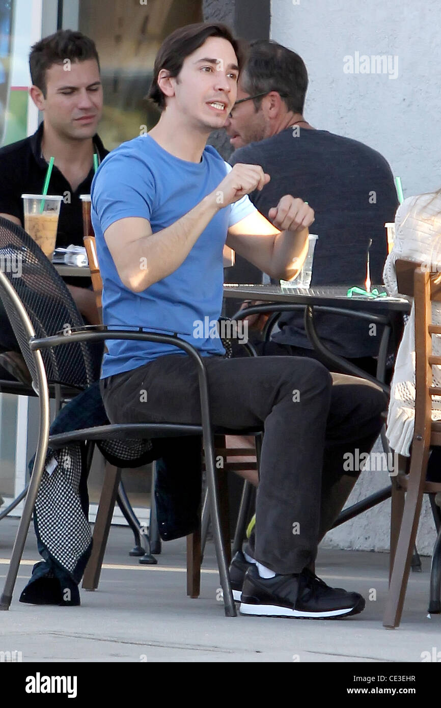 Justin Long talking with friends as he enjoys his beverage outside a ...