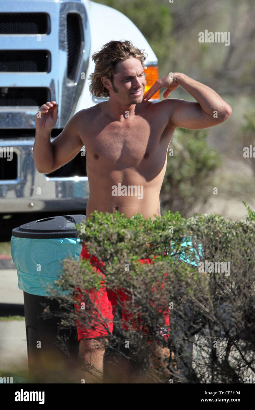 Cast members of the television show '90210' film a beach scene with ...