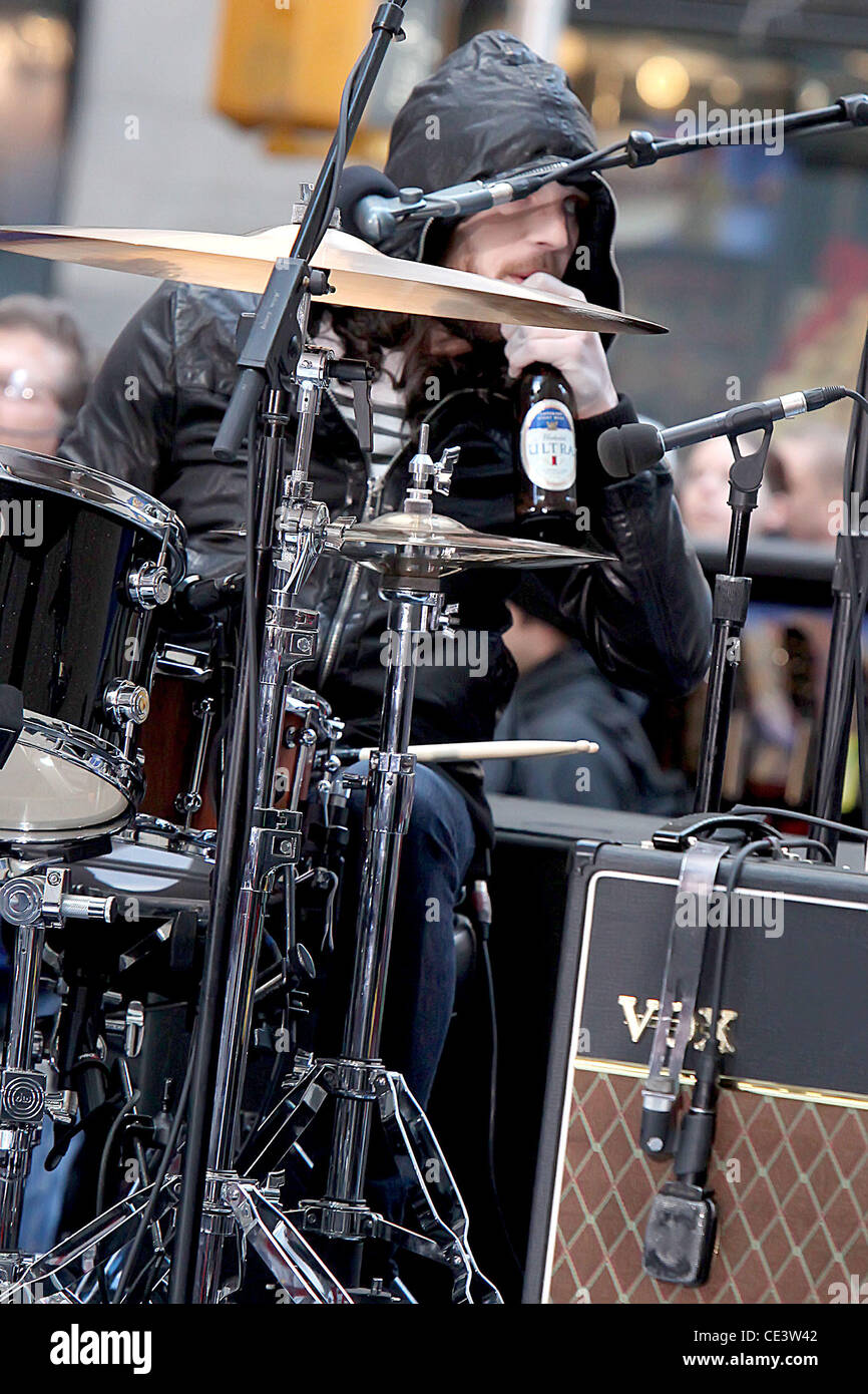 Nathan Followill drinking from a bottle of Michelob Ultra beer on stage ...