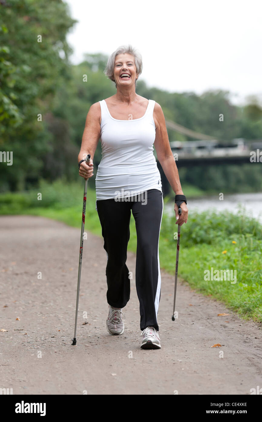 Senior woman walking in park hi-res stock photography and images - Alamy