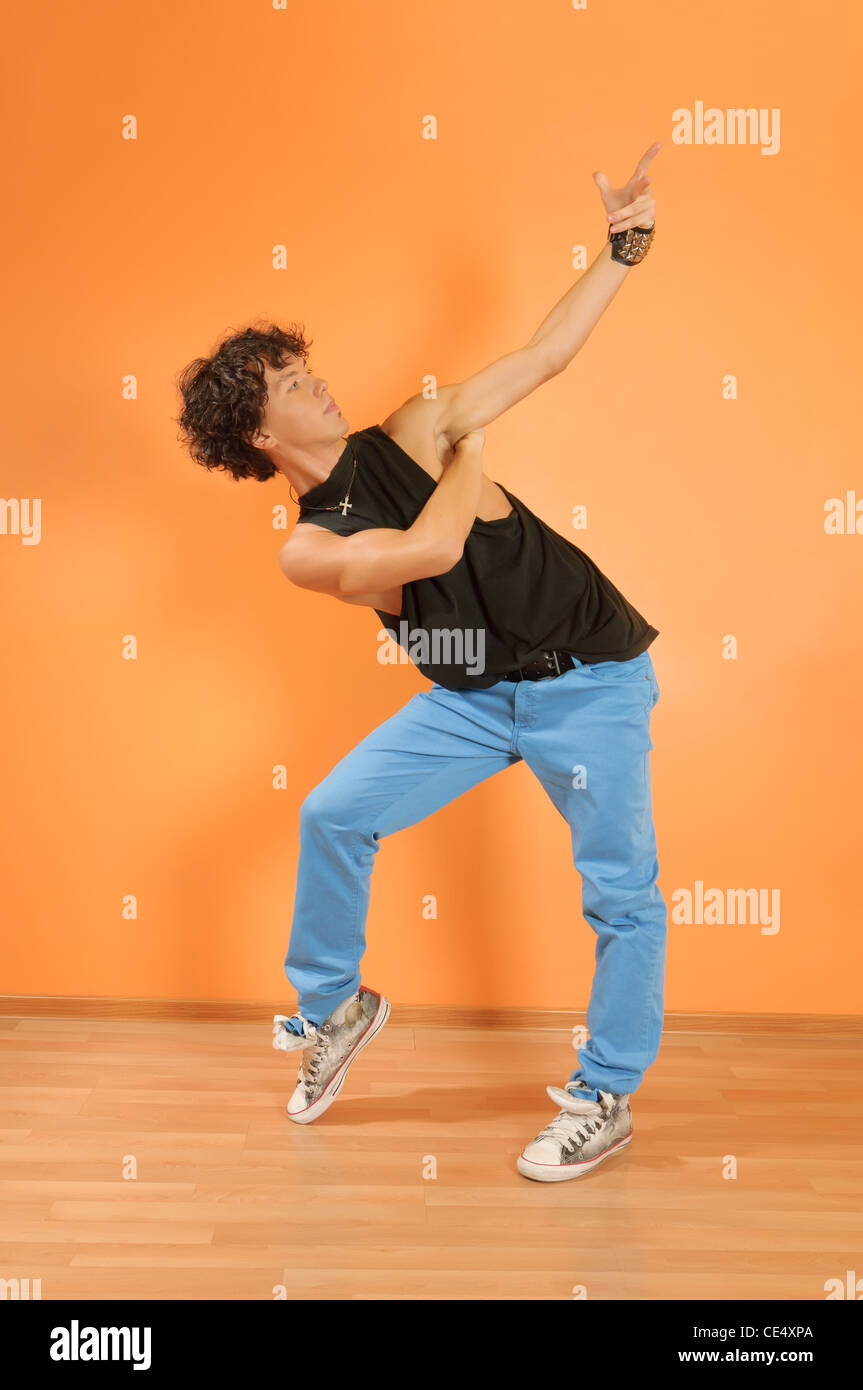 Young man perform break dancing moves on vivid background Stock Photo ...