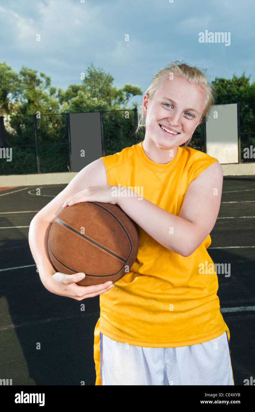 Teenage girl with basketball at streetball playground smiling Stock ...