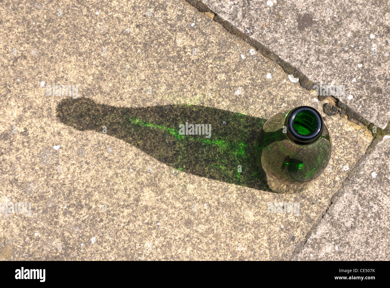 A green bottle throwing a shadow on the path Stock Photo - Alamy